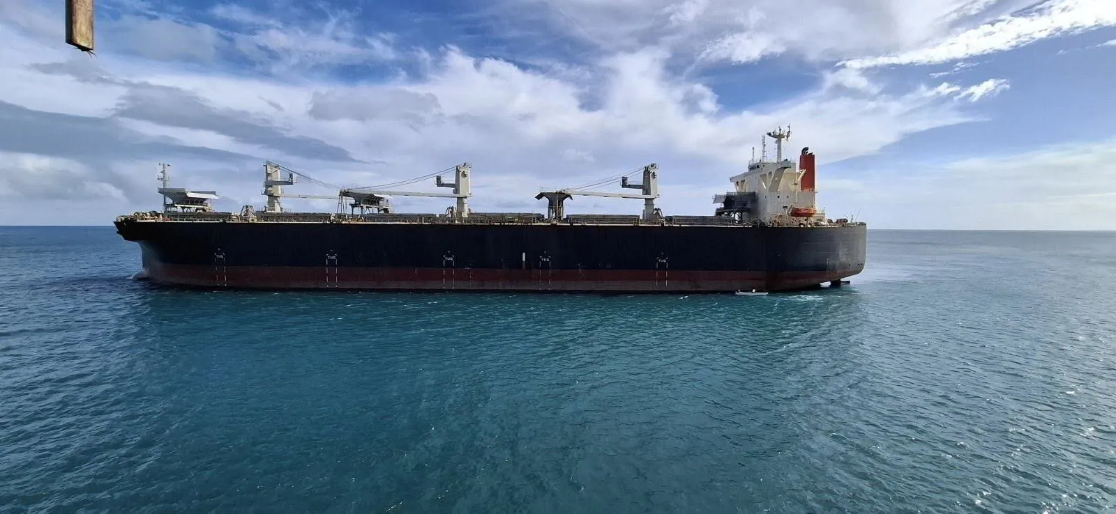 Pine Log Barge Loading Underway at Malau Port for Tropik Wood Products Ltd